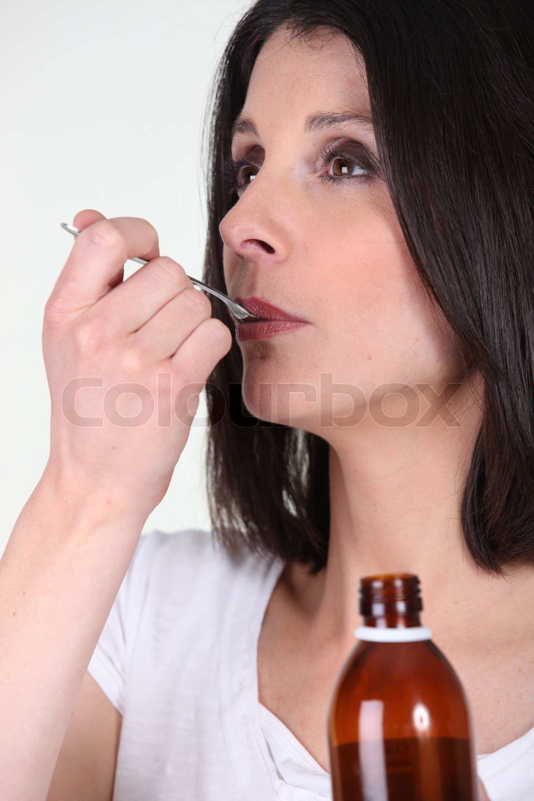 Woman taking cough syrup | Stock image | Colourbox
