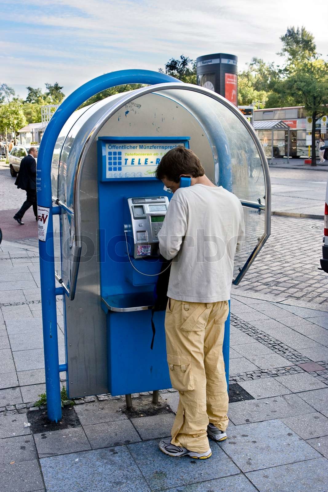 A man talking on a public pay phone in Berlin | Stock image | Colourbox