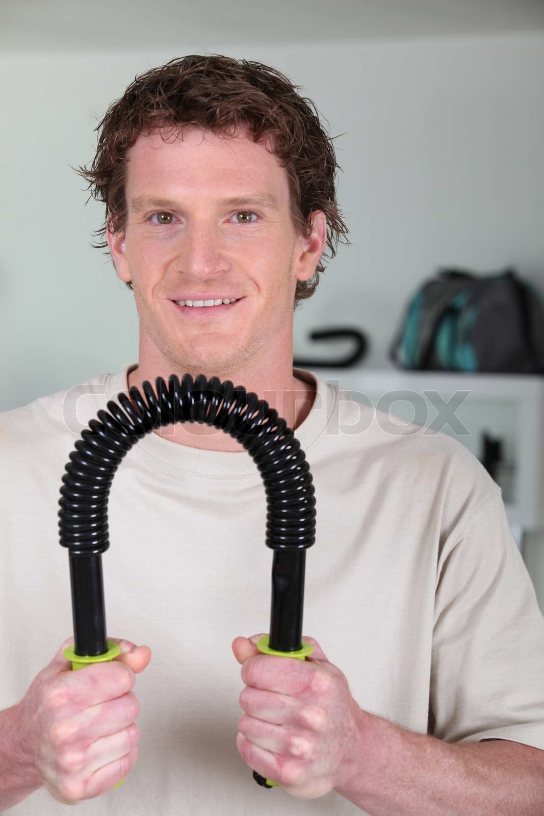 Man squeezing an expander bar | Stock image | Colourbox