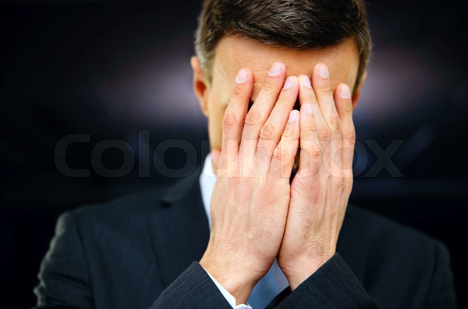 Frustrated businessman with hands on face | Stock image | Colourbox