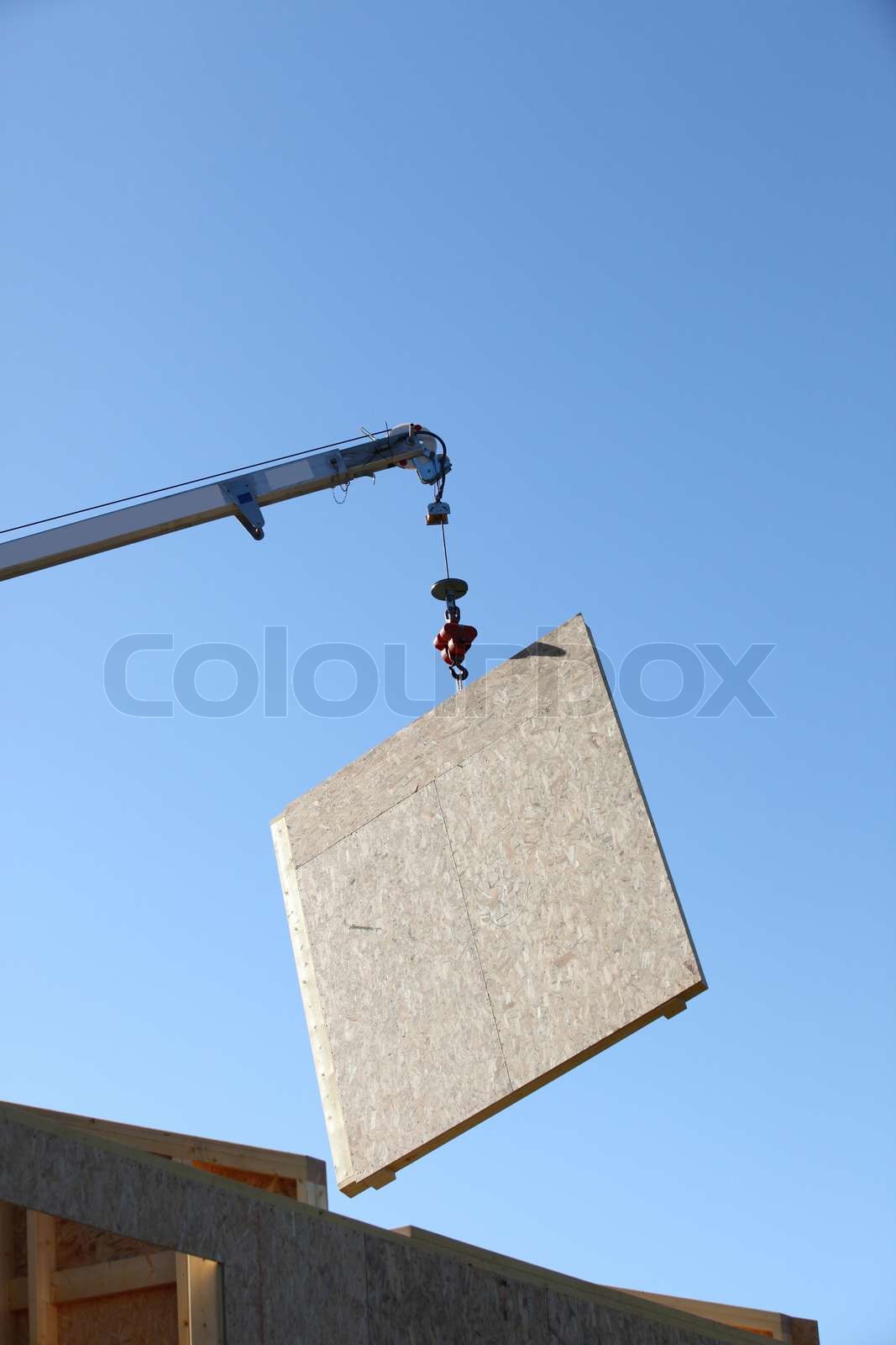 Wooden panel being lifted by crane | Stock image | Colourbox