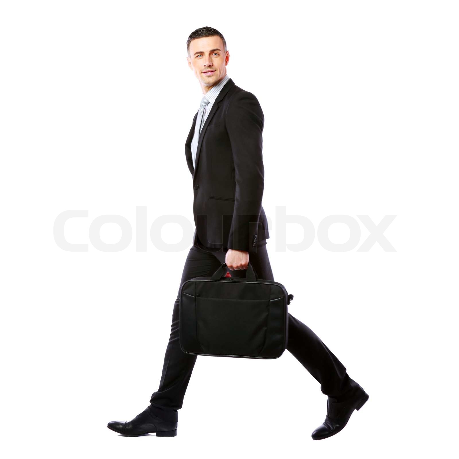 Businessman walking with laptop bag isolated on a white background ...