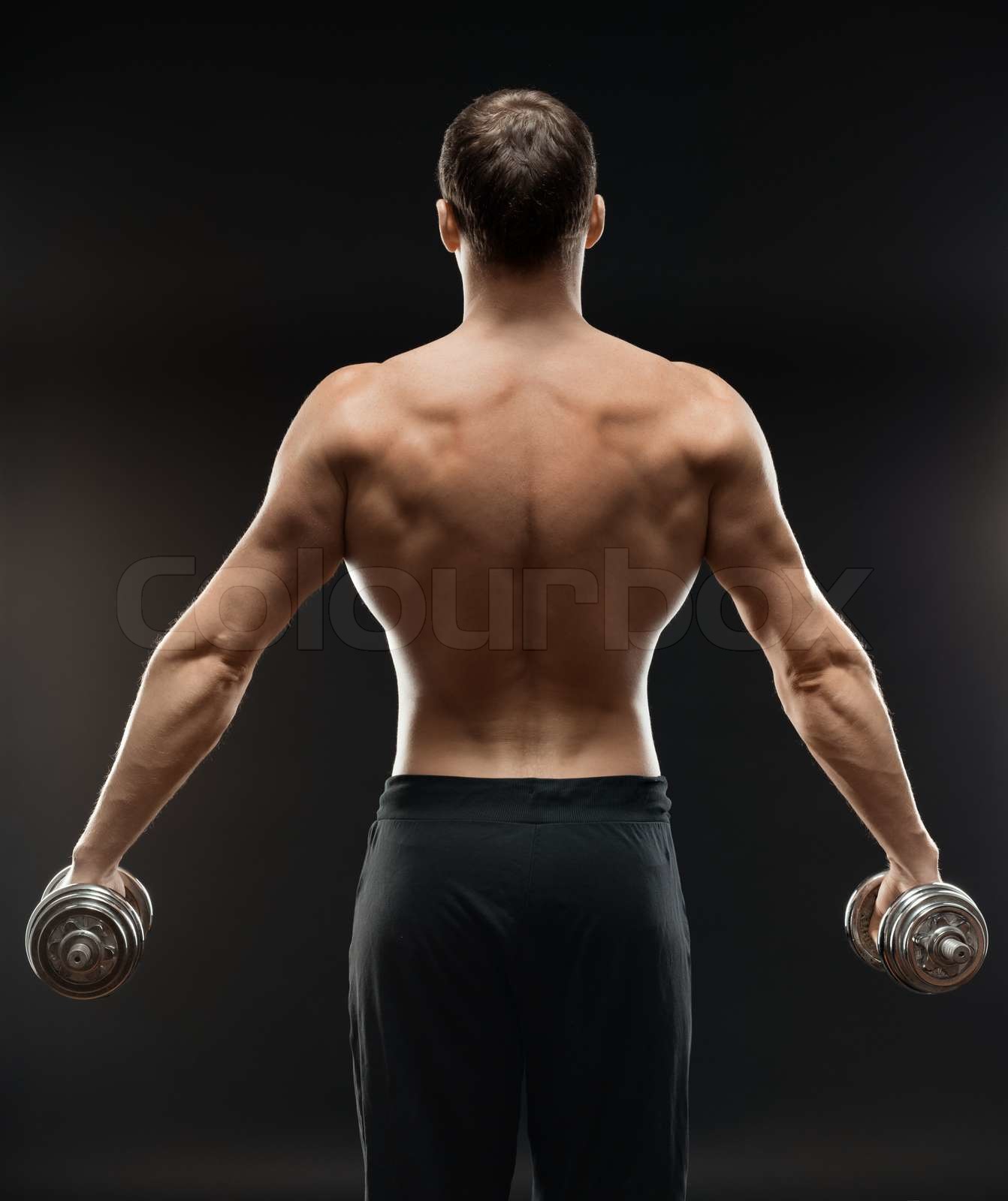 bodybuilder does exercise with dumbbells | Stock image | Colourbox