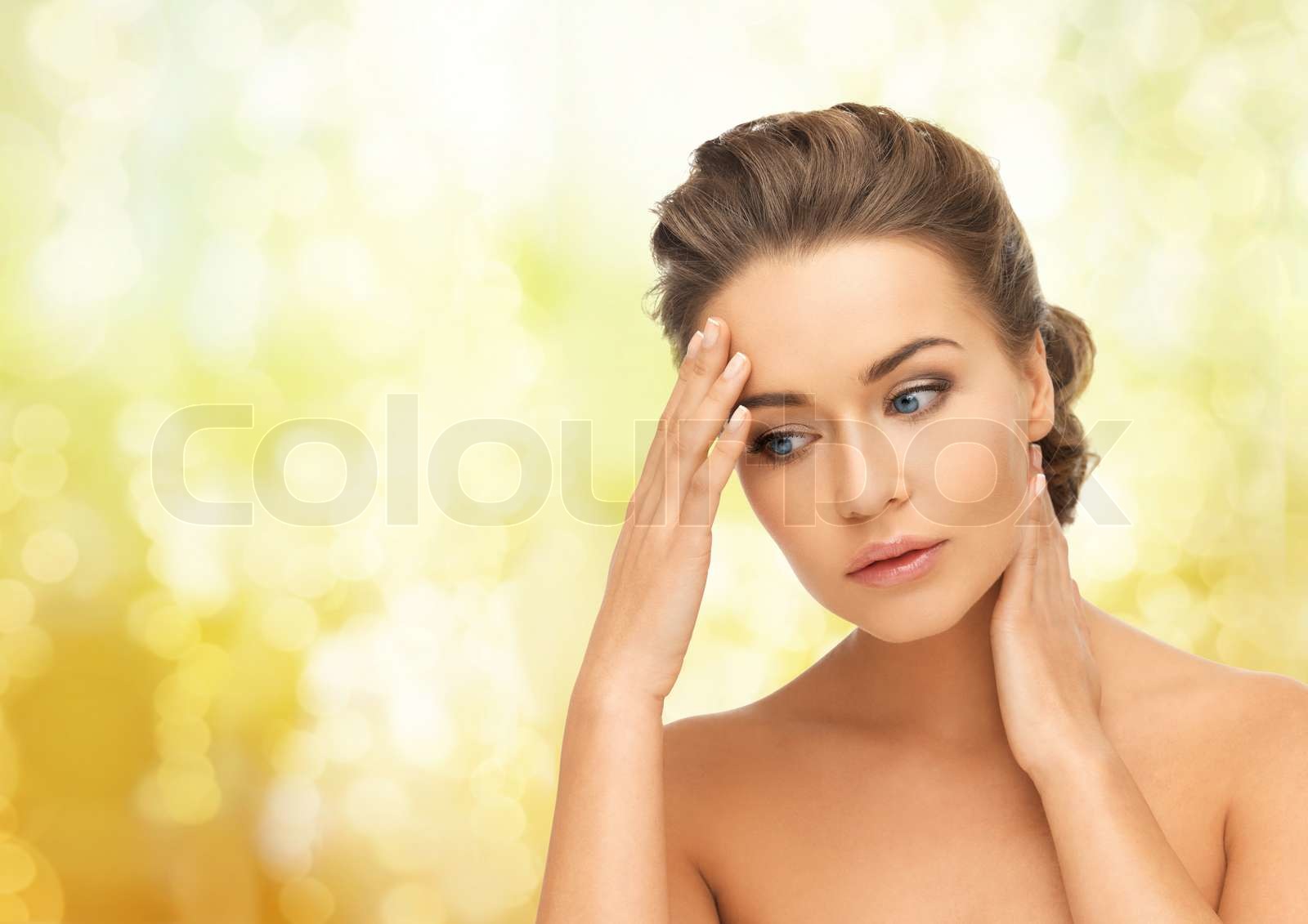 woman holding hands on her neck and forehead | Stock image | Colourbox