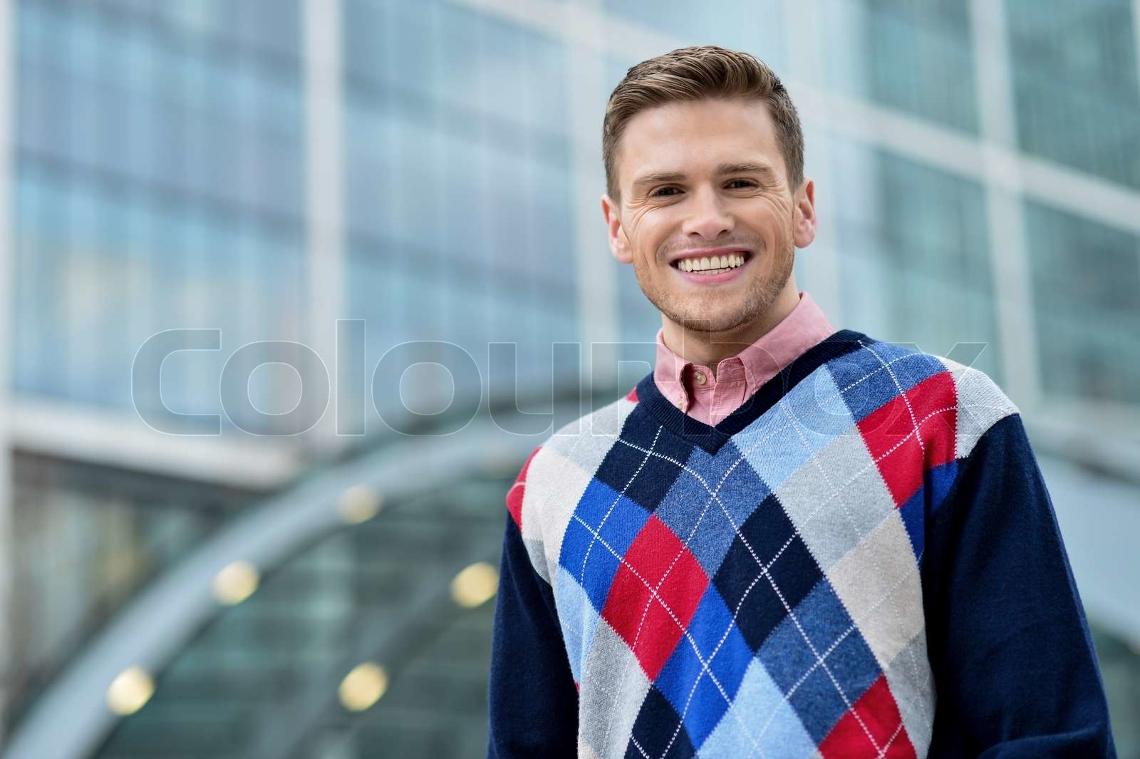Young man standing outside modern building | Stock image | Colourbox