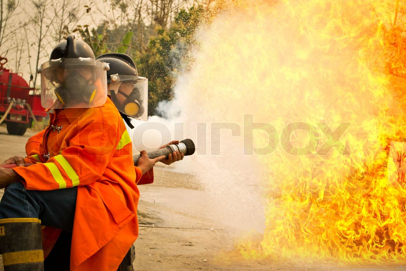 Firemen in action fighting fire during training | Stock image | Colourbox