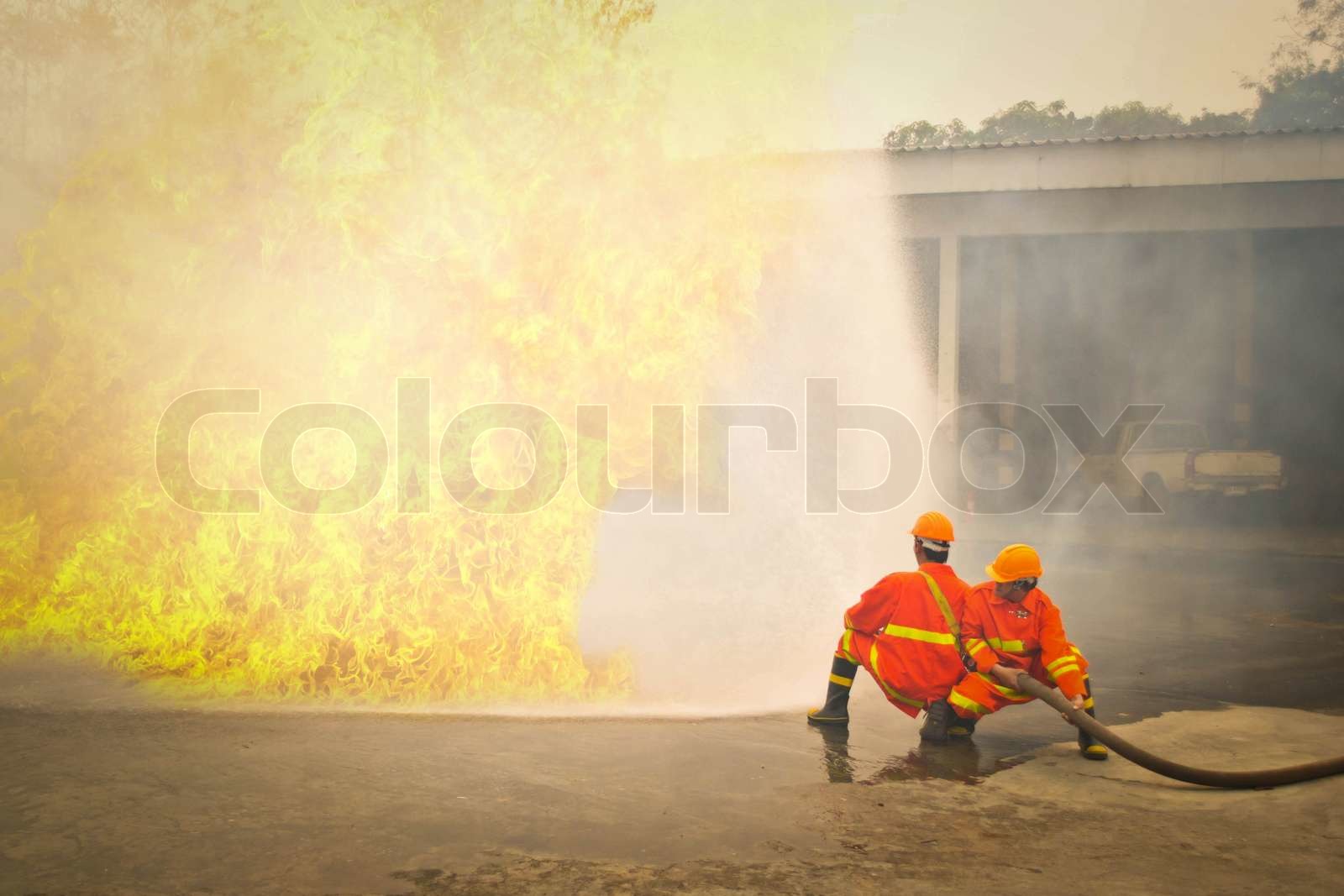 Firemen in action fighting fire during training | Stock image | Colourbox