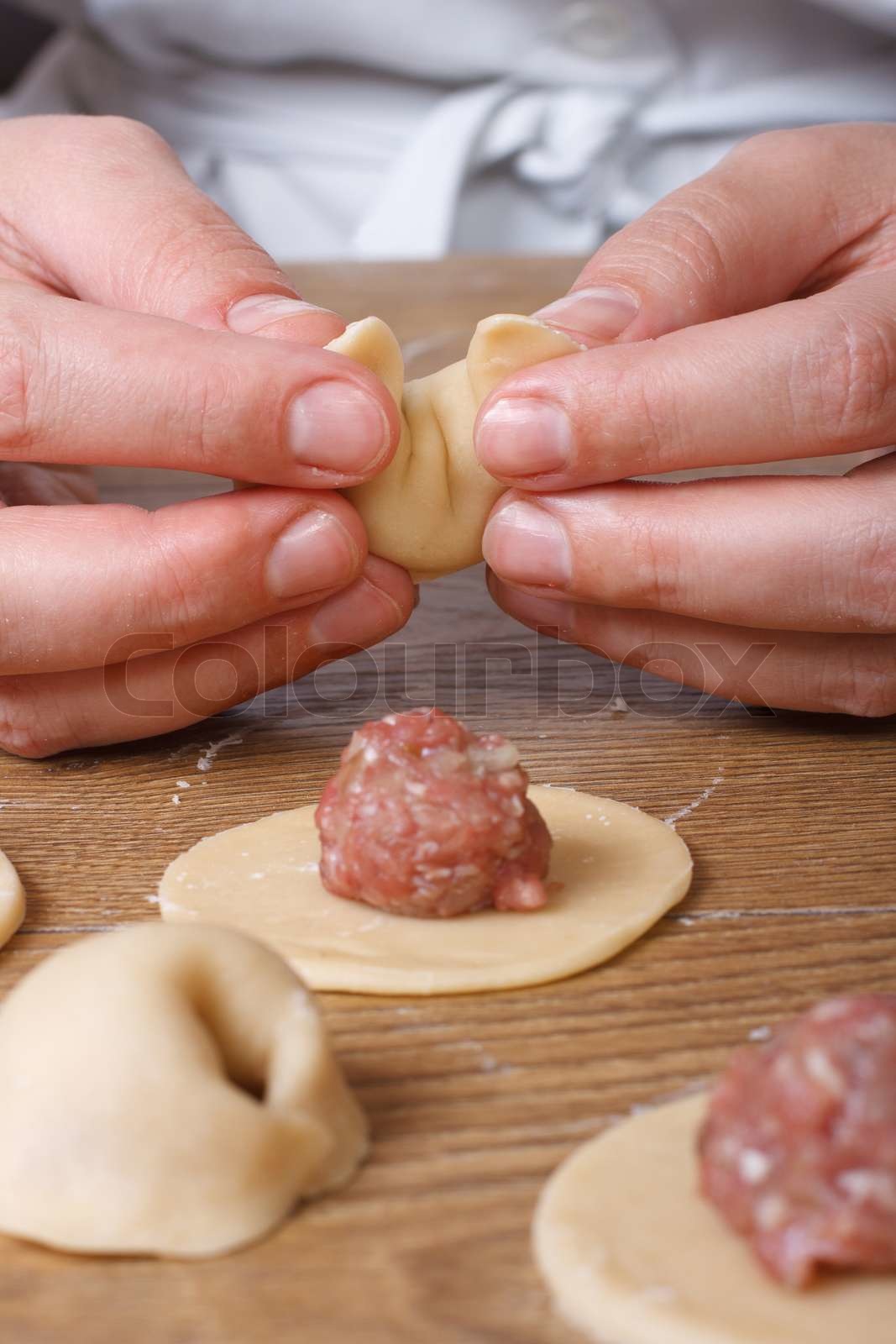 Hands cooks prepare dumplings close-up vertical | Stock image | Colourbox