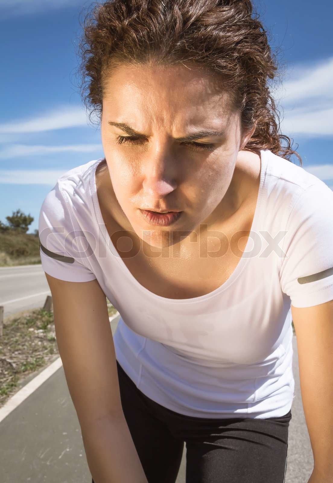 Tired runner girl sweating after running with sun | Stock image | Colourbox