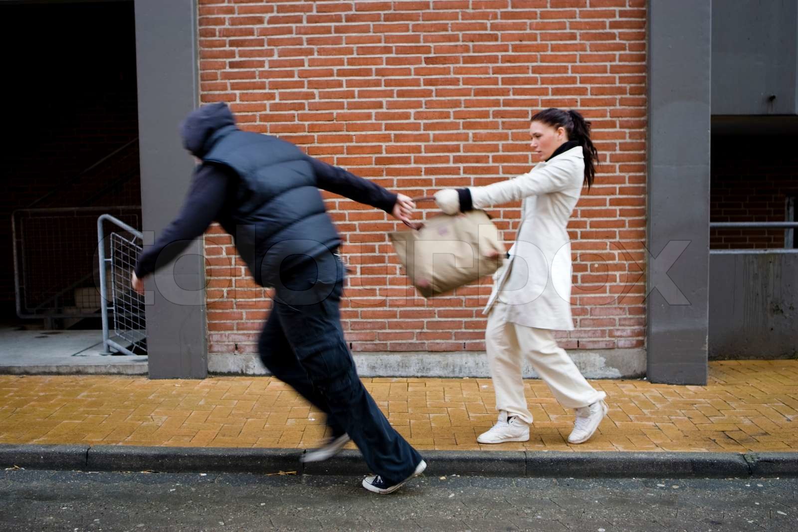 A male mugger grabbing a bag from a woman | Stock image | Colourbox