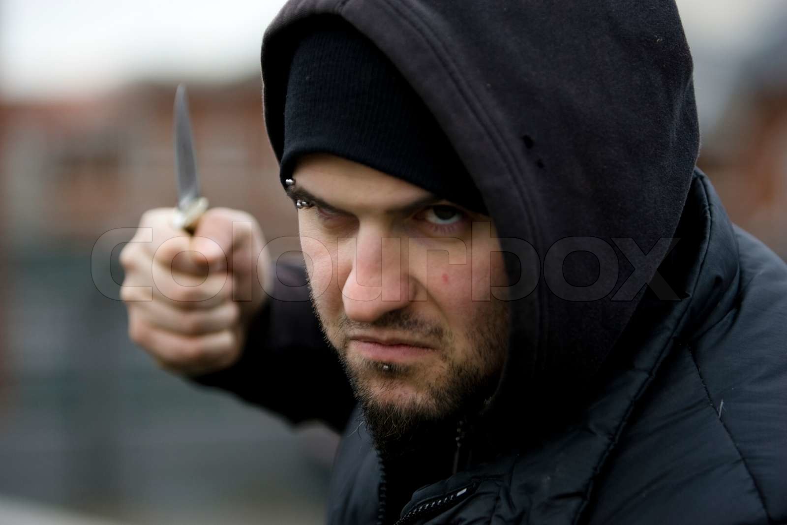 Face of a male mugger pointing a knife | Stock image | Colourbox