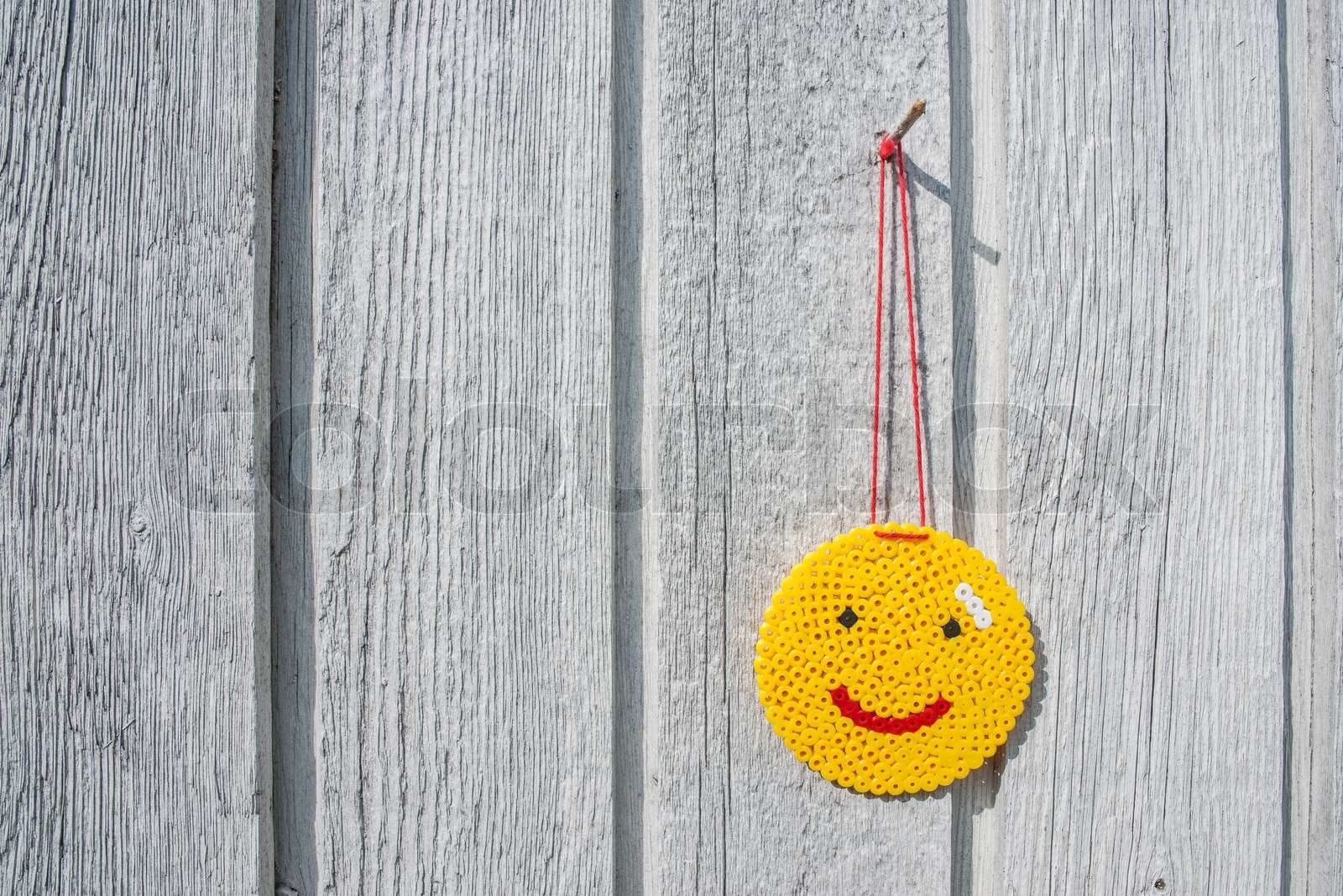 Smiley figure hanging on a wall | Stock image | Colourbox