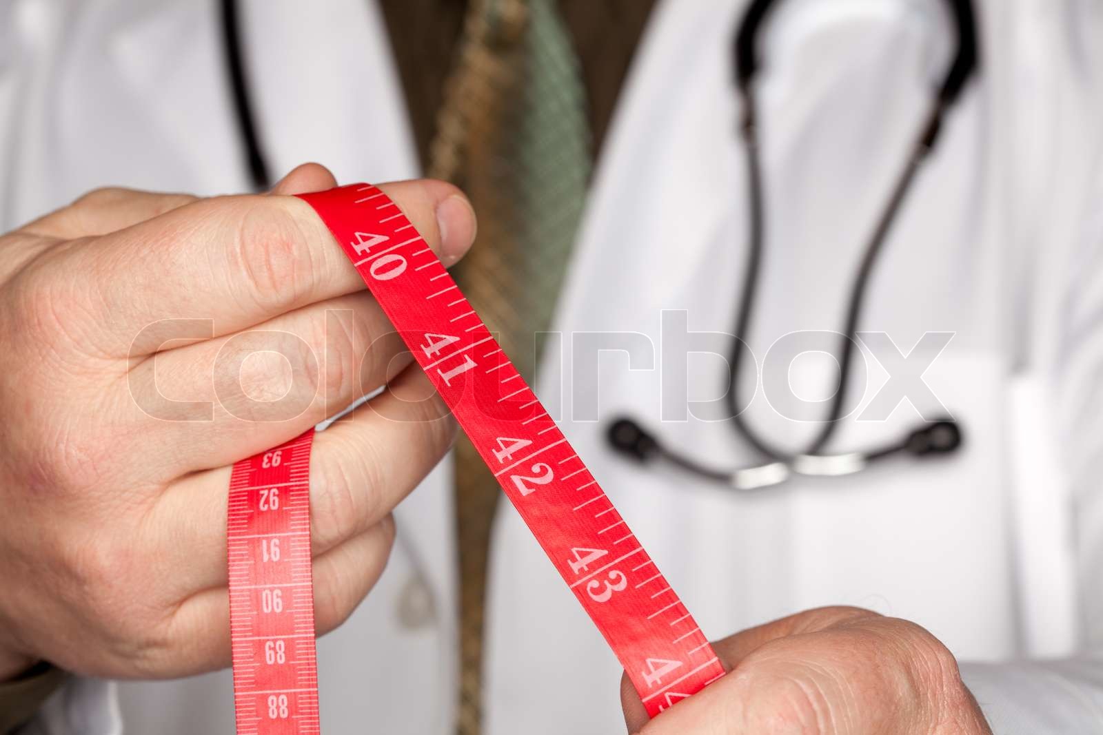 Doctor with Stethoscope Holding Measuring Tape | Stock image | Colourbox