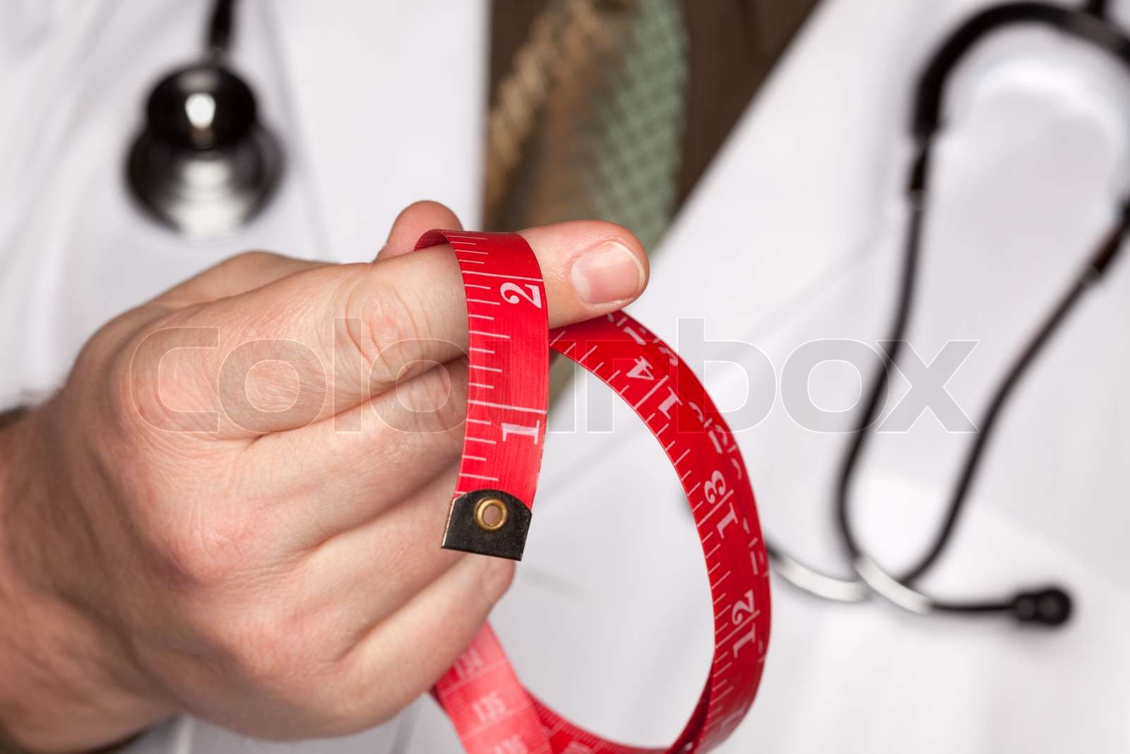 Doctor with Stethoscope Holding Measuring Tape | Stock image | Colourbox