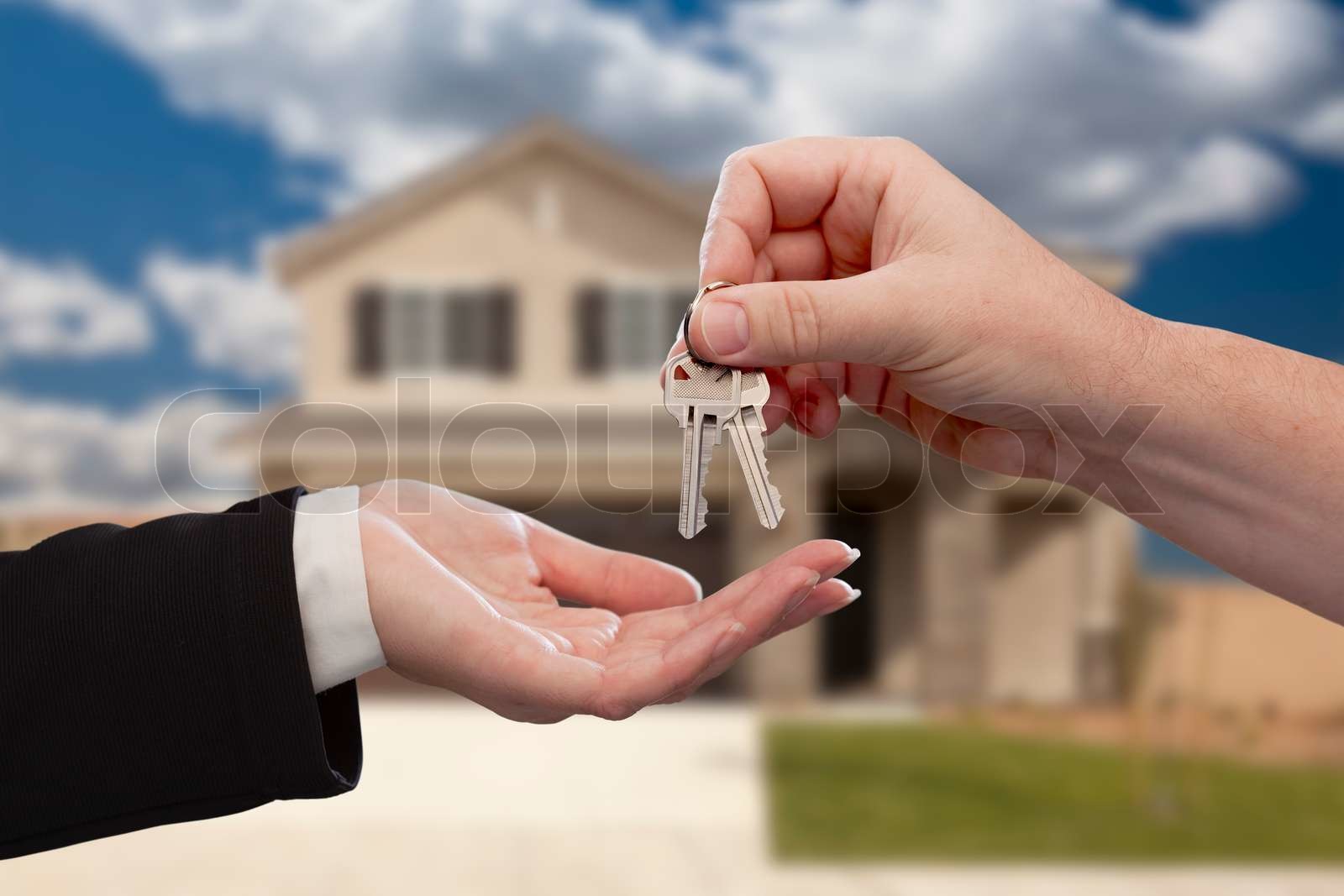 Handing Over the House Keys in Front of New Home | Stock image | Colourbox