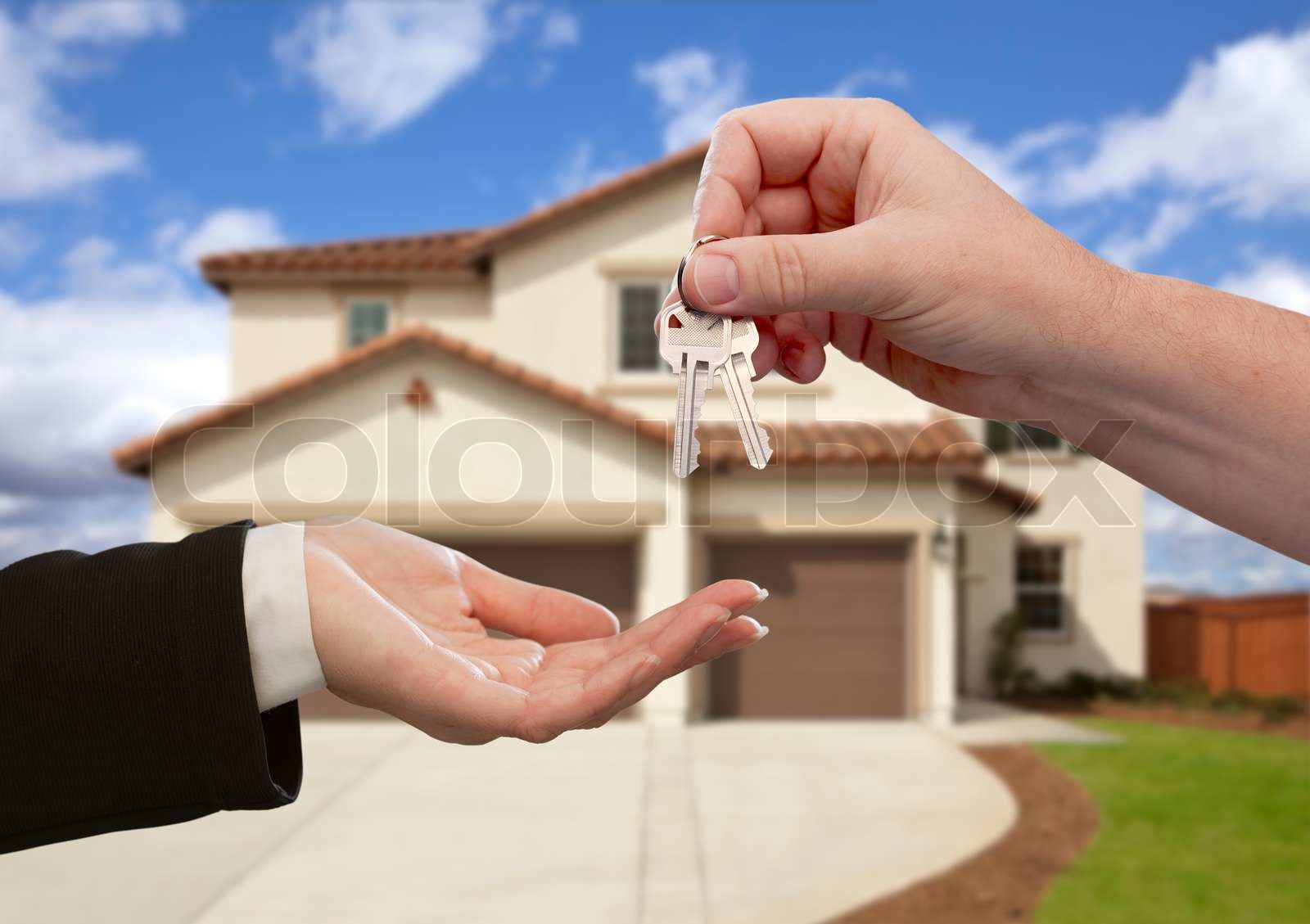 Handing Over the House Keys in Front of New Home | Stock image | Colourbox