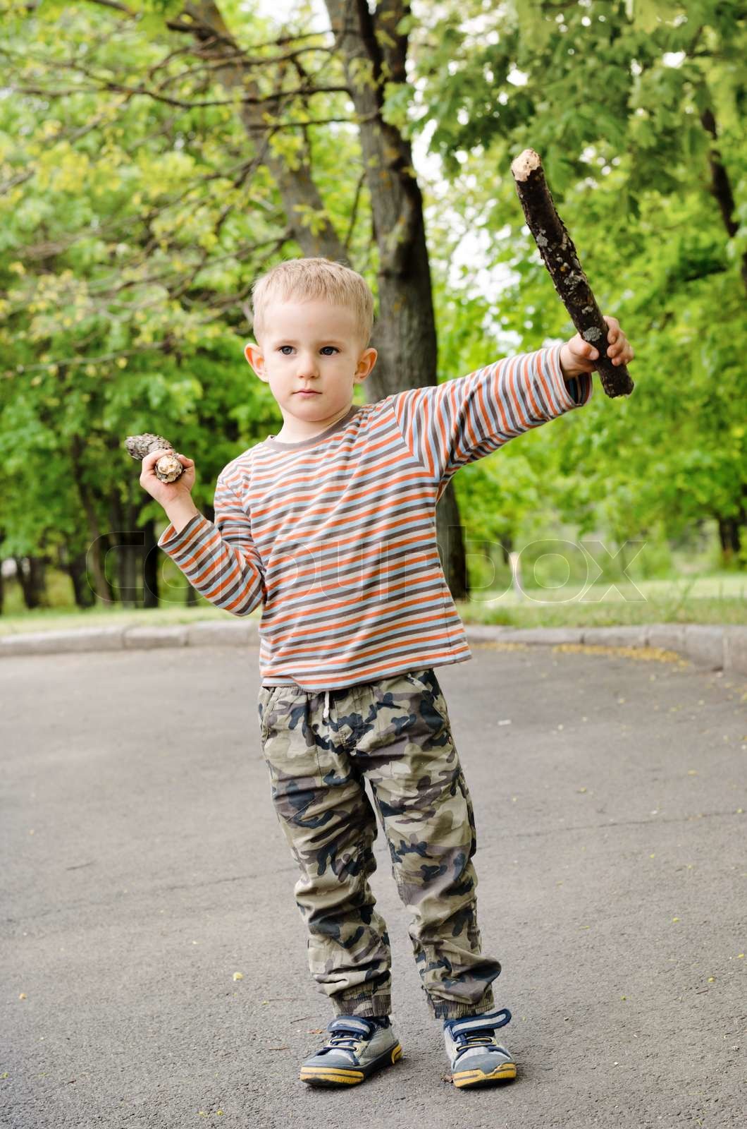 Little boy playing with fighting sticks | Stock image | Colourbox