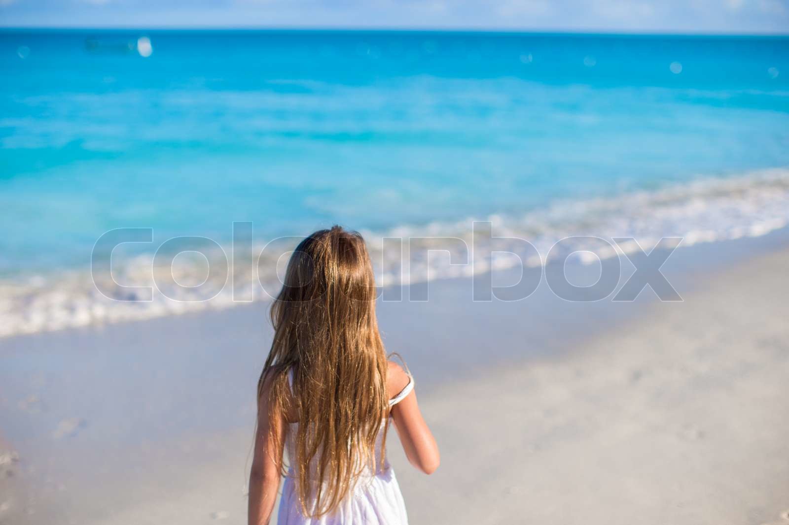 Back view of little girl at white beach during summer vacation | Stock ...