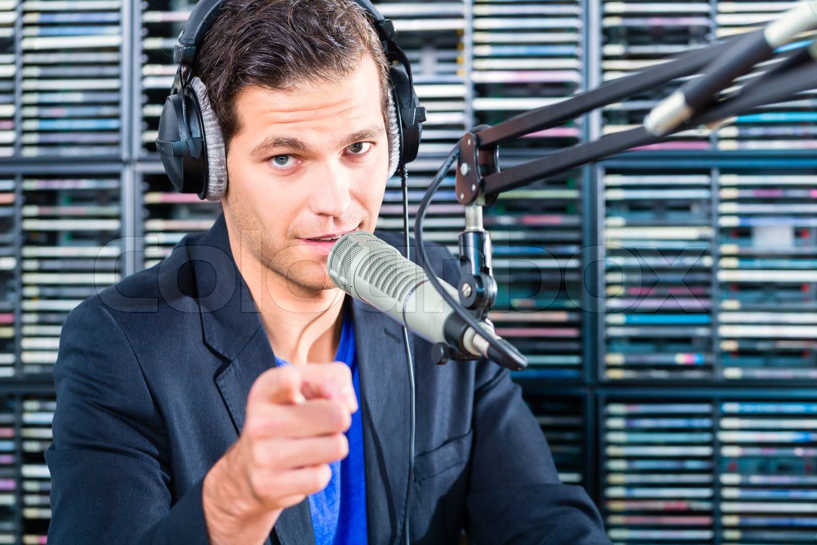 Male radio presenter in radio station on air | Stock image | Colourbox