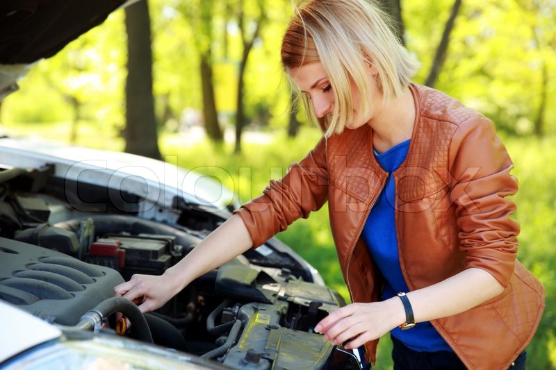 Blonde woman checking her car engine | Stock image | Colourbox