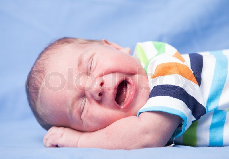 Crying newborn baby boy lays on his ... | Stock image | Colourbox