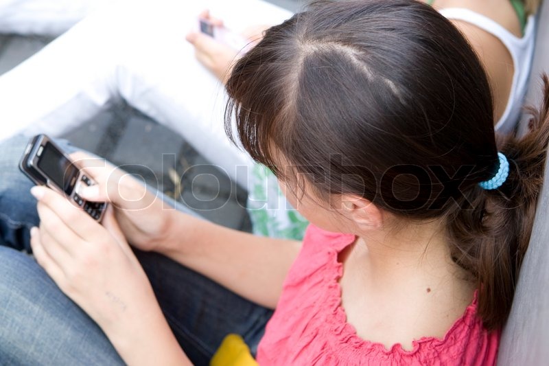 A teenage girl using her cellphone | Stock image | Colourbox
