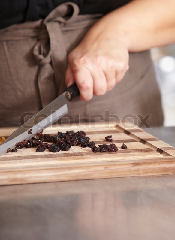 A female hand chopping raisins | Stock image | Colourbox