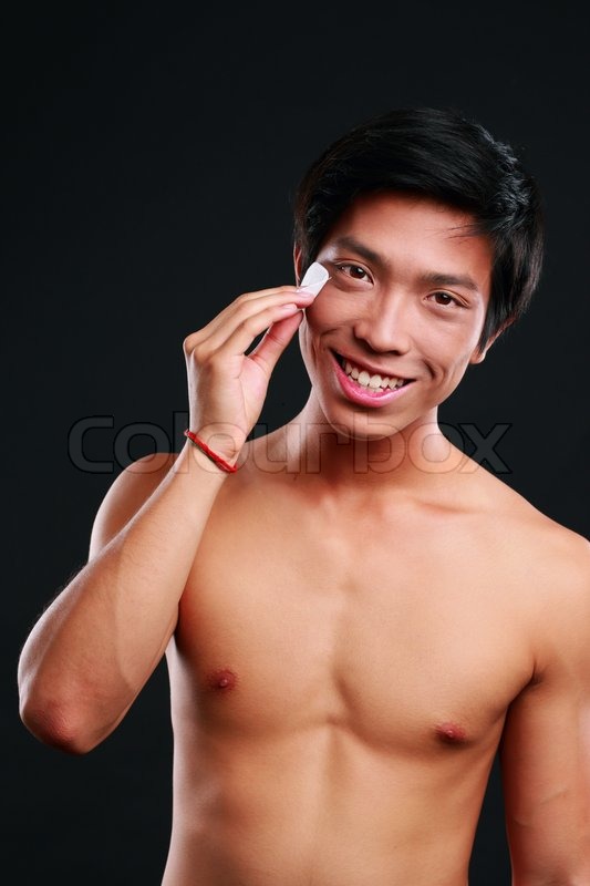 Happy asian man wipes his face with ... | Stock image | Colourbox