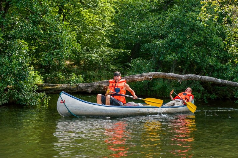 Two men in a canoe on a river by a ... | Stock image | Colourbox