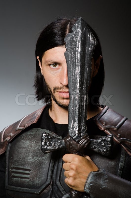 Angry knight with sword against dark ... | Stock image | Colourbox