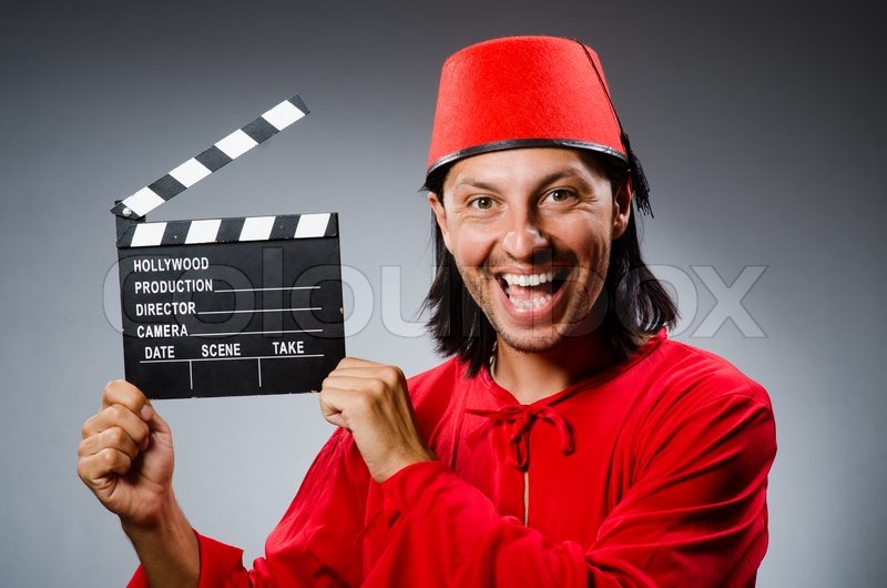 Man wearing fez hat with movie board | Stock image | Colourbox