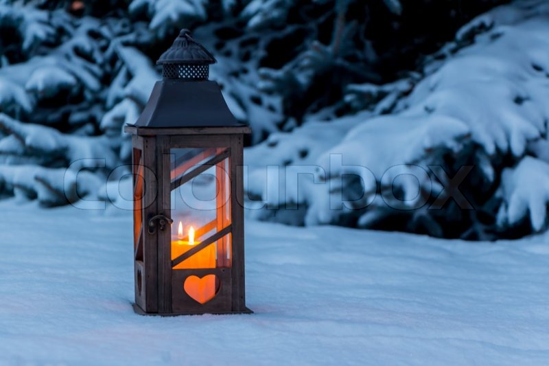 A lantern lights up in the snow at ... | Stock image | Colourbox