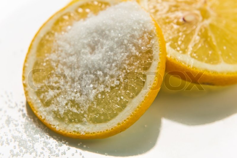 Fresh lemon with sugar on a white plate | Stock image | Colourbox