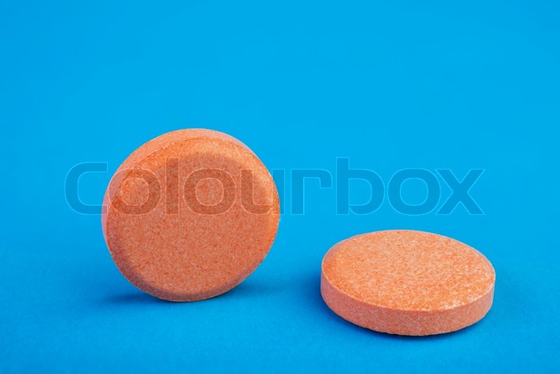 Two orange tablets on a blue ... | Stock image | Colourbox