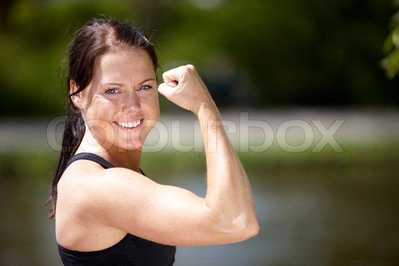 Glad kvinde spænder hendes armmuskler | Stock foto | Colourbox