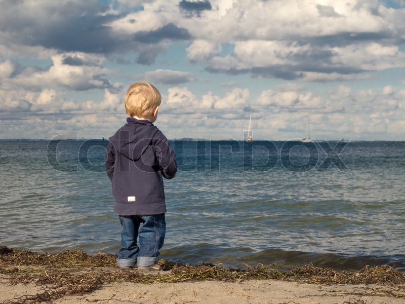 Little boy at a beach looking towards ... | Stock image | Colourbox