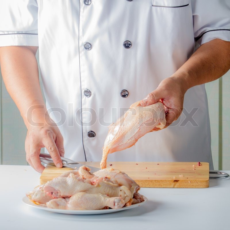 Chef chopping raw chicken for cooking | Stock image | Colourbox