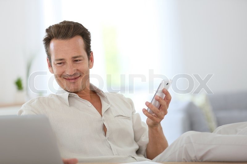 Relaxed man working from home and using ... | Stock image | Colourbox