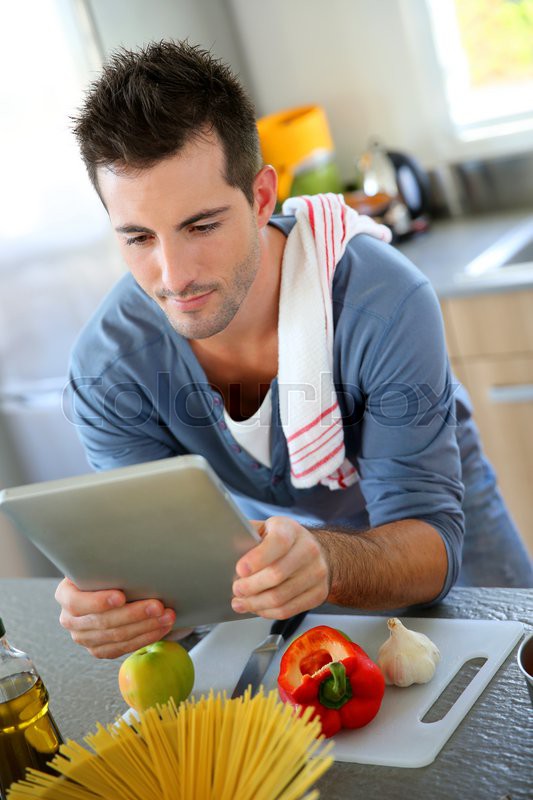 Closeup of smiling man in kitchen using ... | Stock image | Colourbox