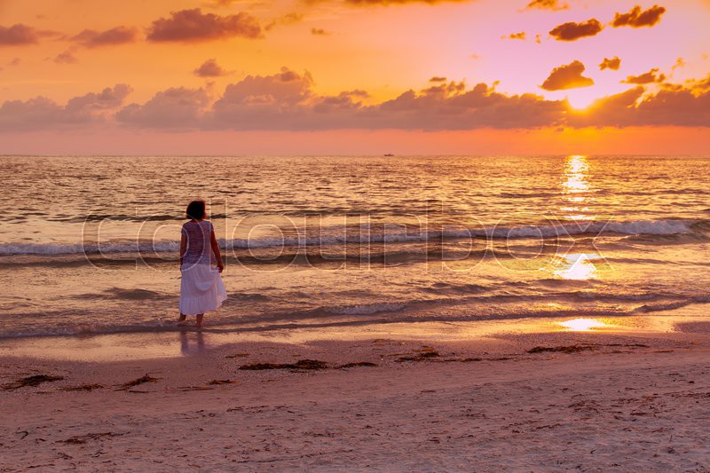 Woman enjoying beautiful sunset on ... | Stock image | Colourbox