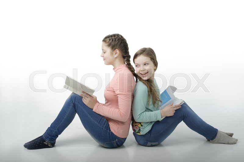 Little girls read books back to back ... | Stock image | Colourbox
