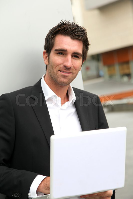 Salesman working outside on laptop ... | Stock image | Colourbox