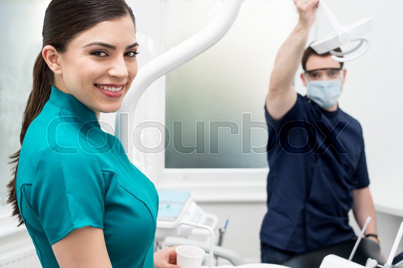 Female dental assistant smiling at the ... | Stock image | Colourbox