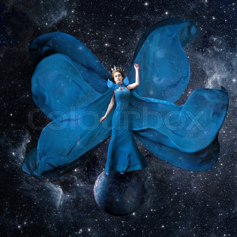 Blue space queen. Beautiful woman in a fluttering dress standing and ...