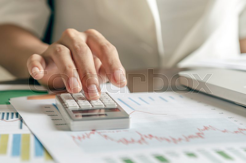 Woman using a calculator in office | Stock image | Colourbox