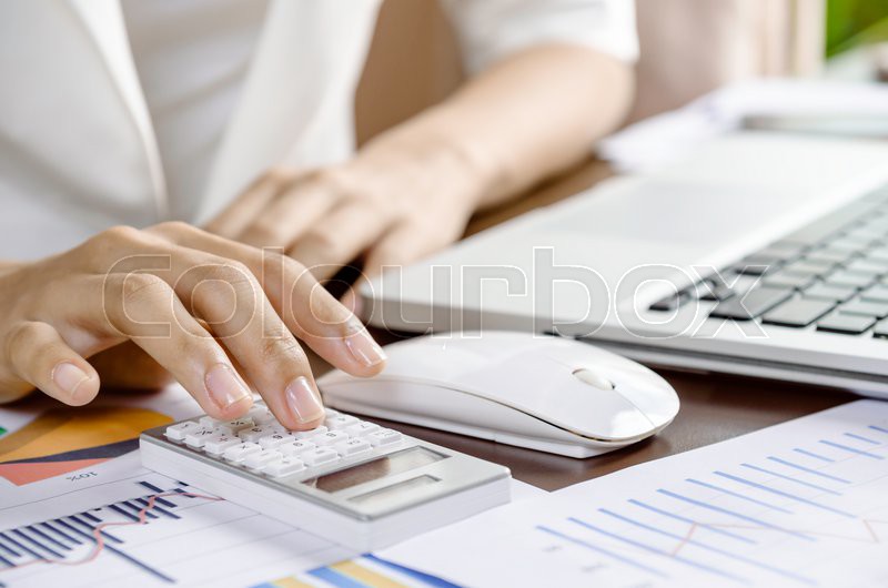 Woman using a calculator in an office | Stock image | Colourbox