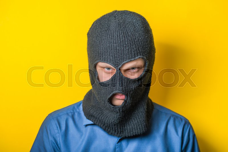 Man close up thief in a mask and a blue ... | Stock image | Colourbox