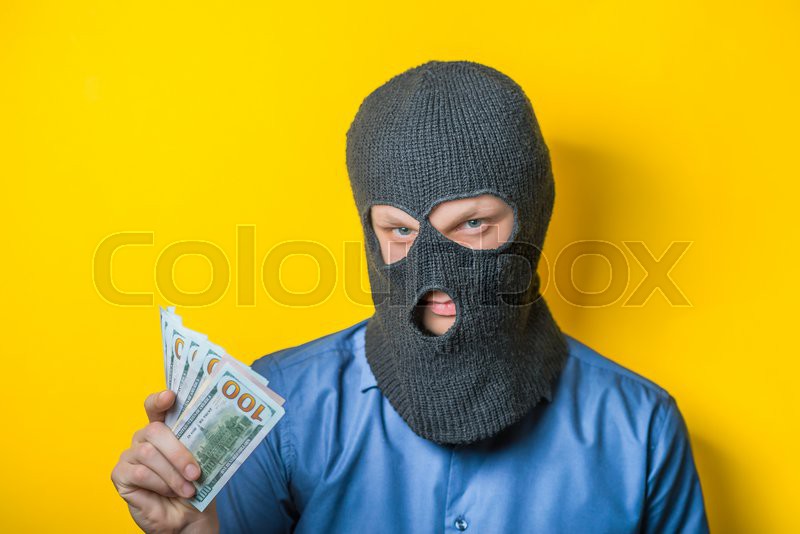Man close up thief in a mask and a blue ... | Stock image | Colourbox