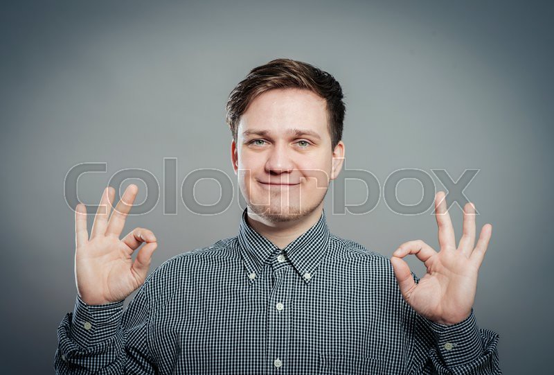 Gesturing OK sign. Cheerful young man ... | Stock Photo | Colourbox