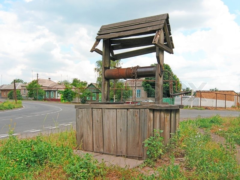 Wooden well in rural landscape | Stock image | Colourbox